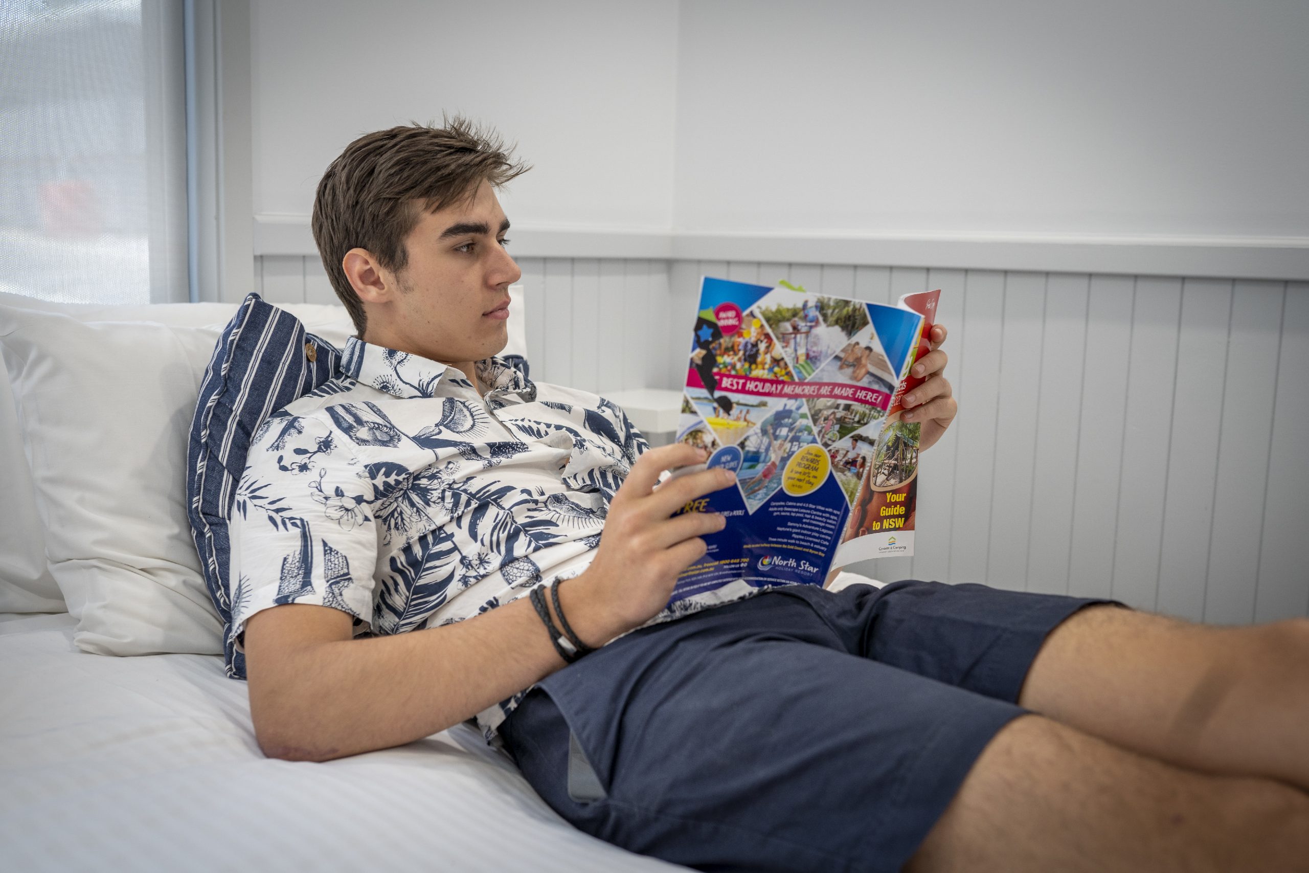 Man reading in bedroom 2 - Surf Beach Holiday Park